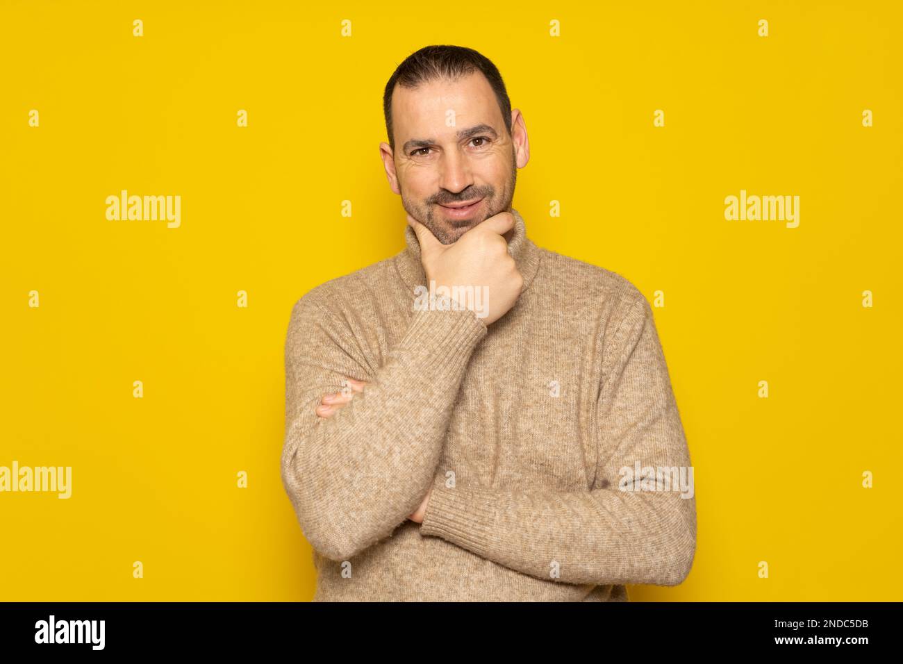 Problem solution. Bearded Hispanic man in a beige turtleneck gets rid ...