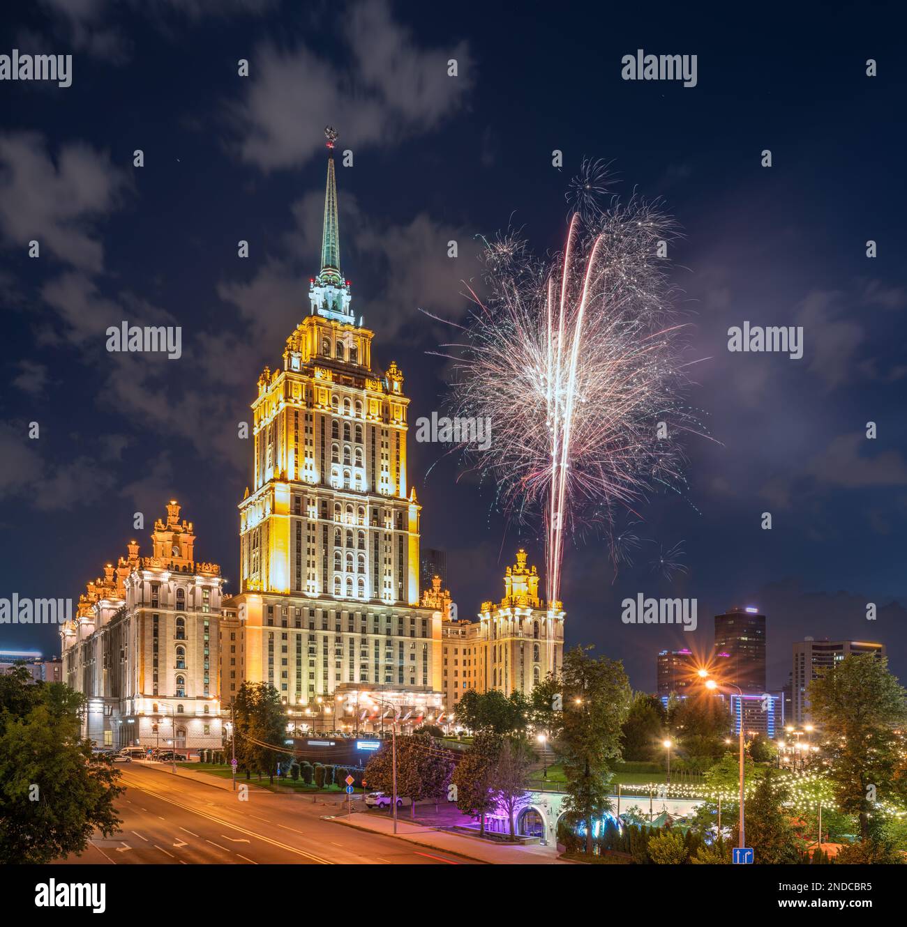 Illuminated high-rise stalinist building at summer night and fireworks ...
