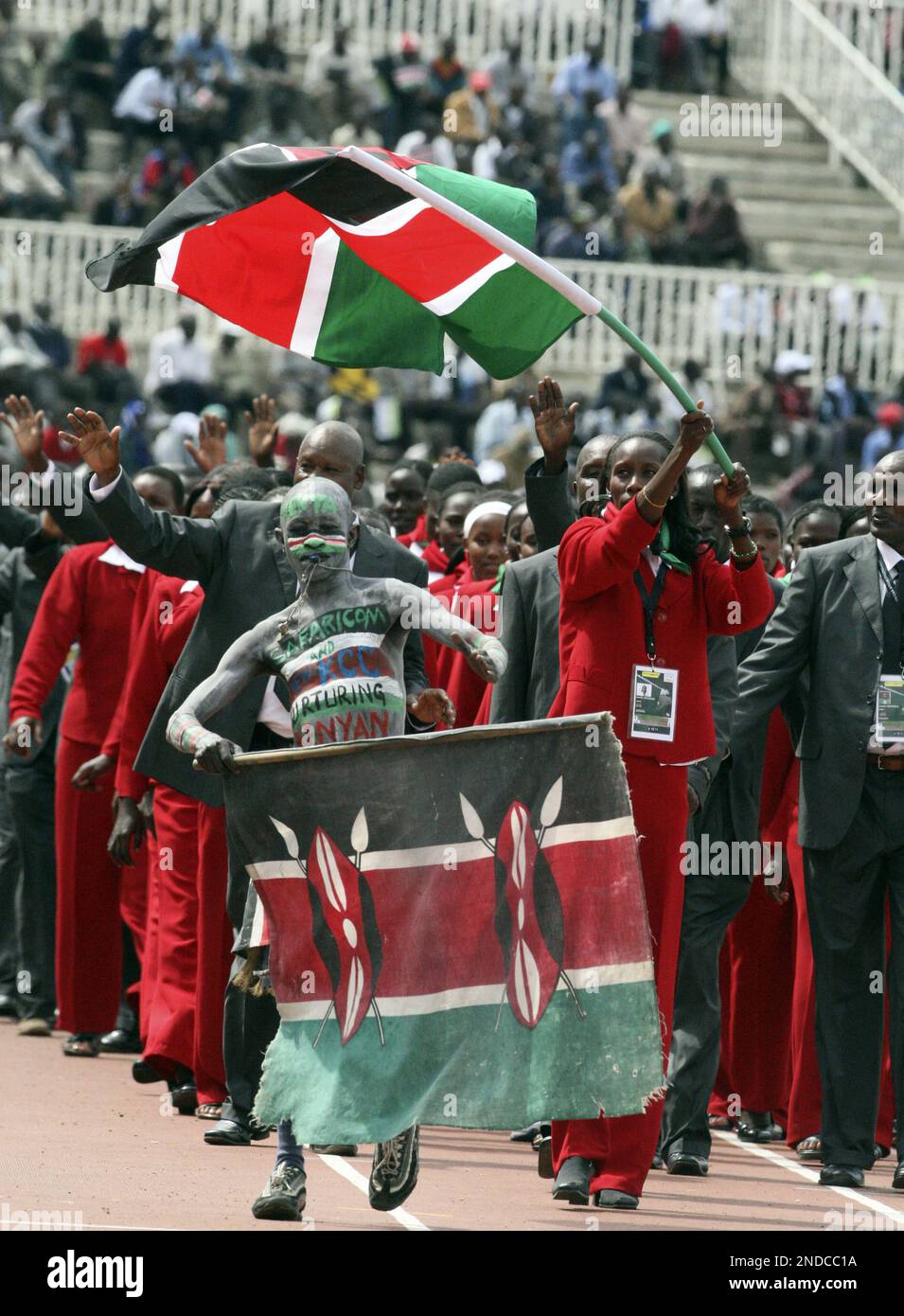 A traditional dancer leads the Kenyan team during the opening, ceremony ...