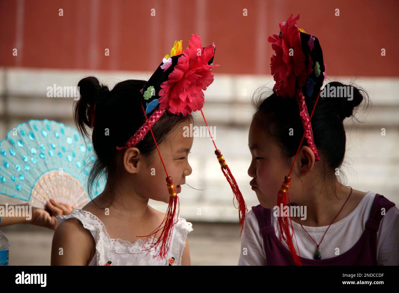 Chinese girls wearing traditional flower headdresses tease each other ...