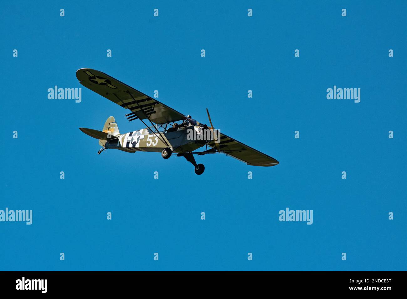 A vintage L-4 Grasshopper WWII fighter plane flies above the ...