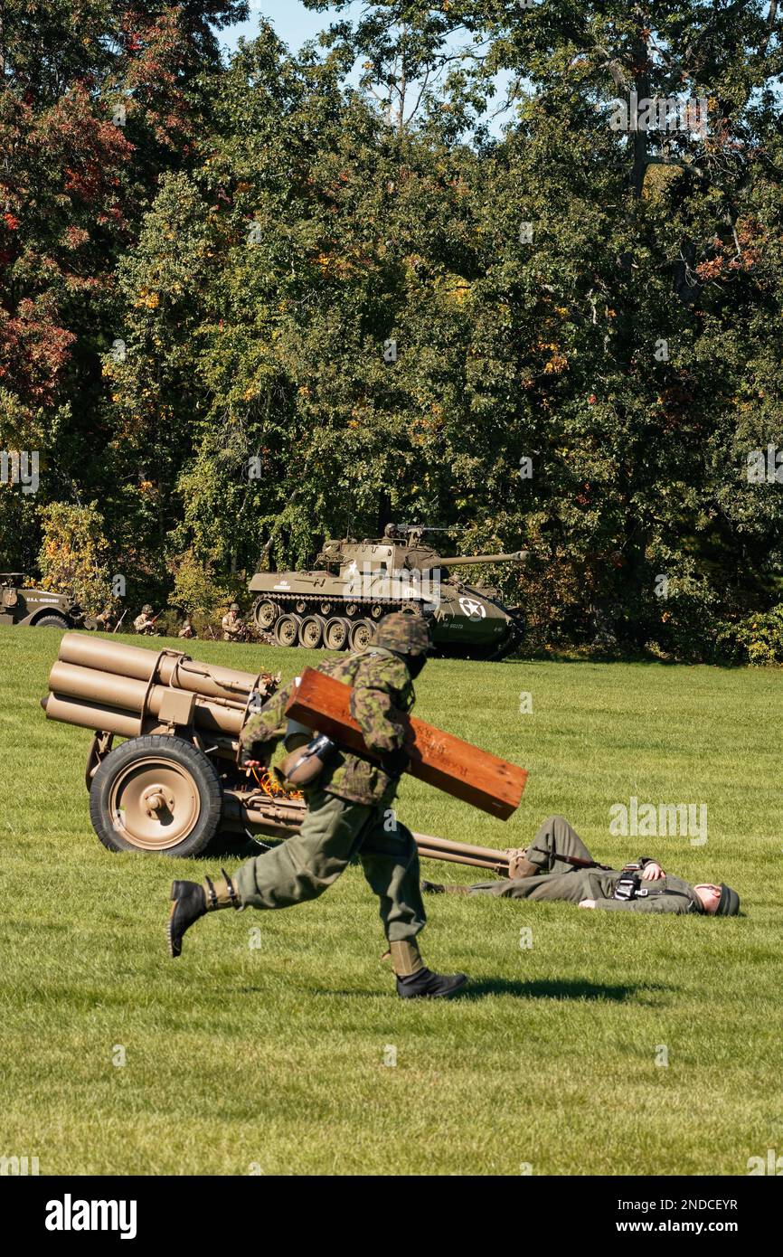 Soldiers running across a WWII battlefield during a reenactment at the ...