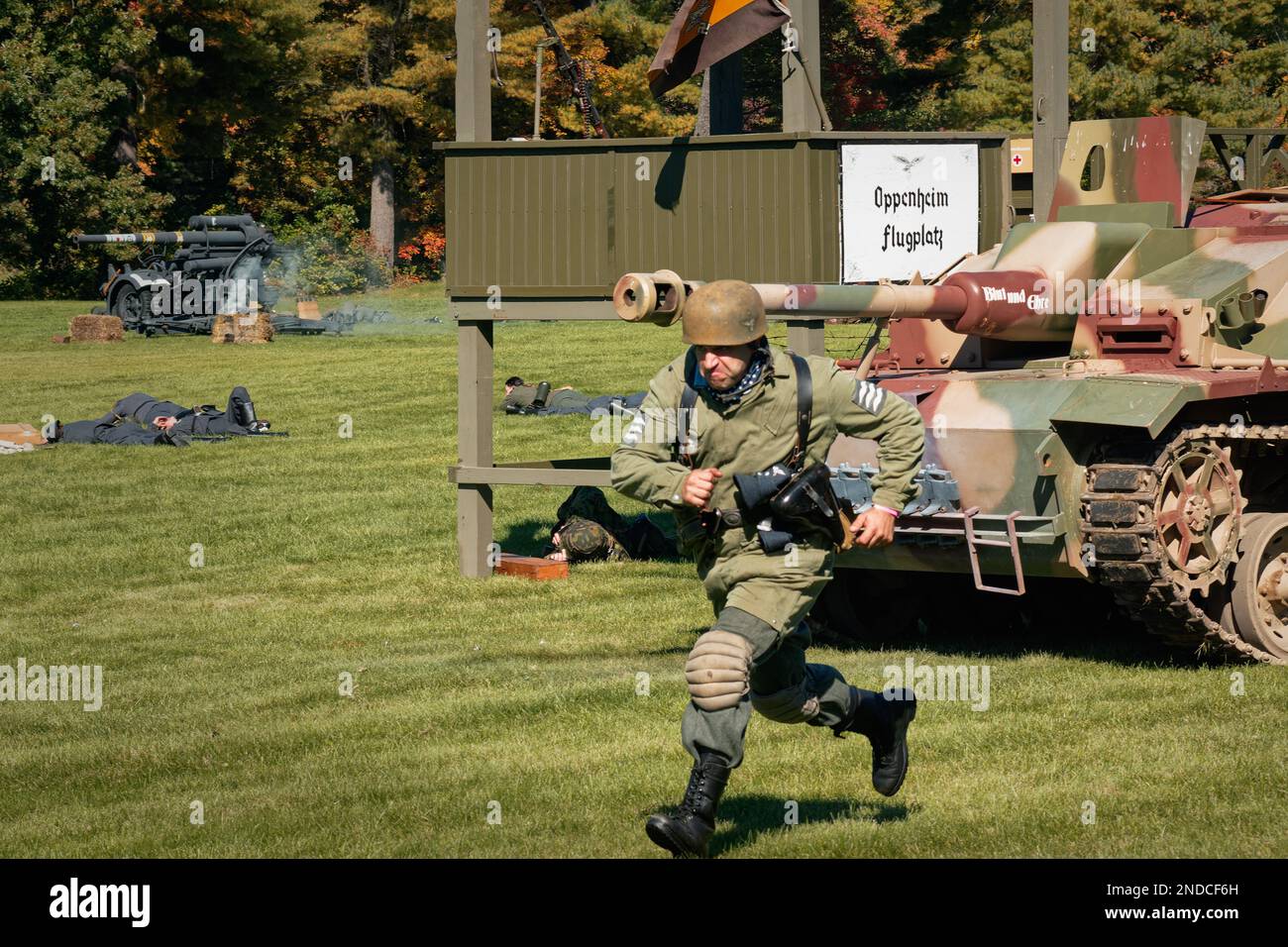 Soldiers running across a WWII battlefield during a reenactment at the ...