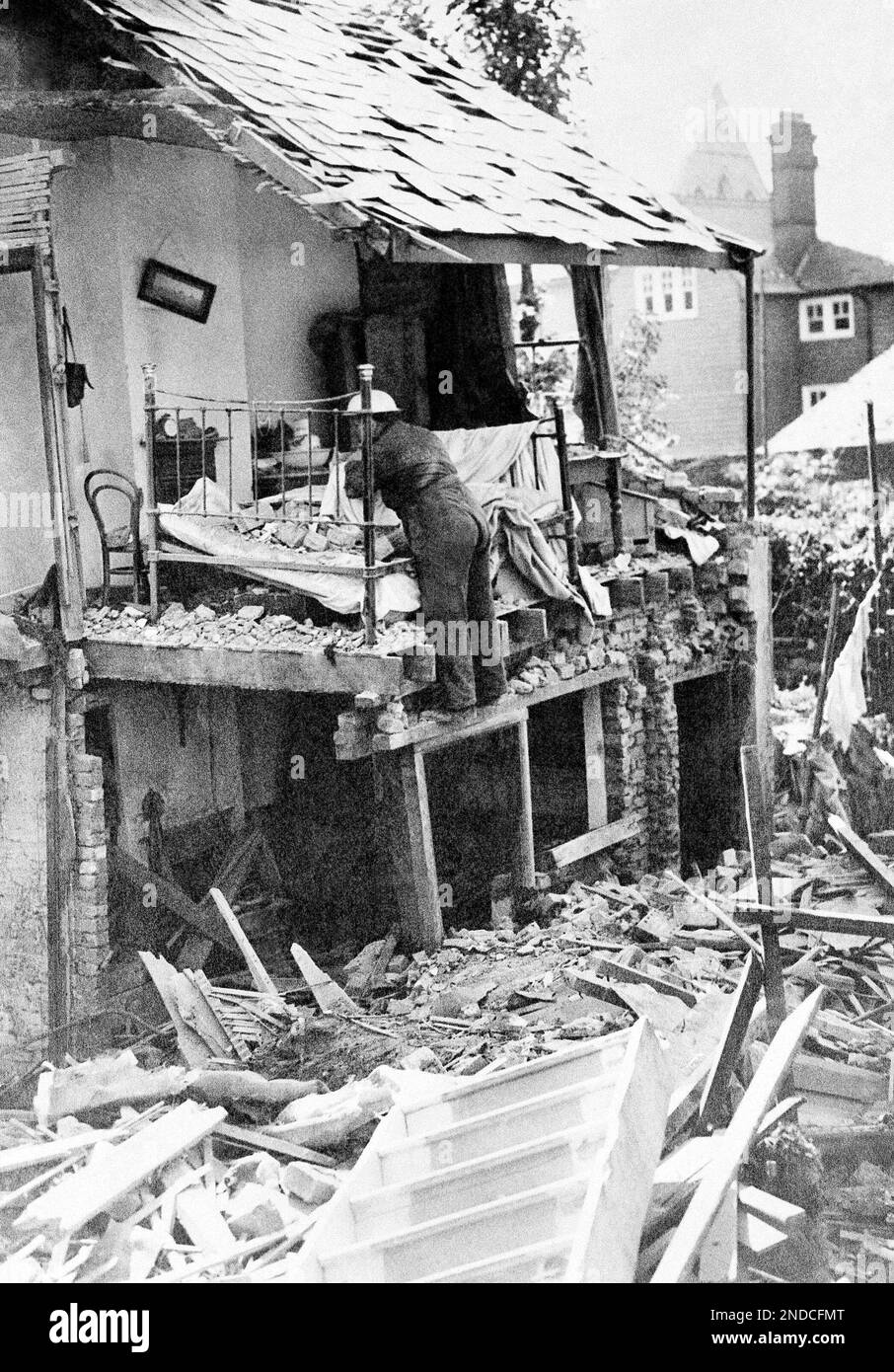 An air raid warden is shown as he examined a damaged home in Dover ...