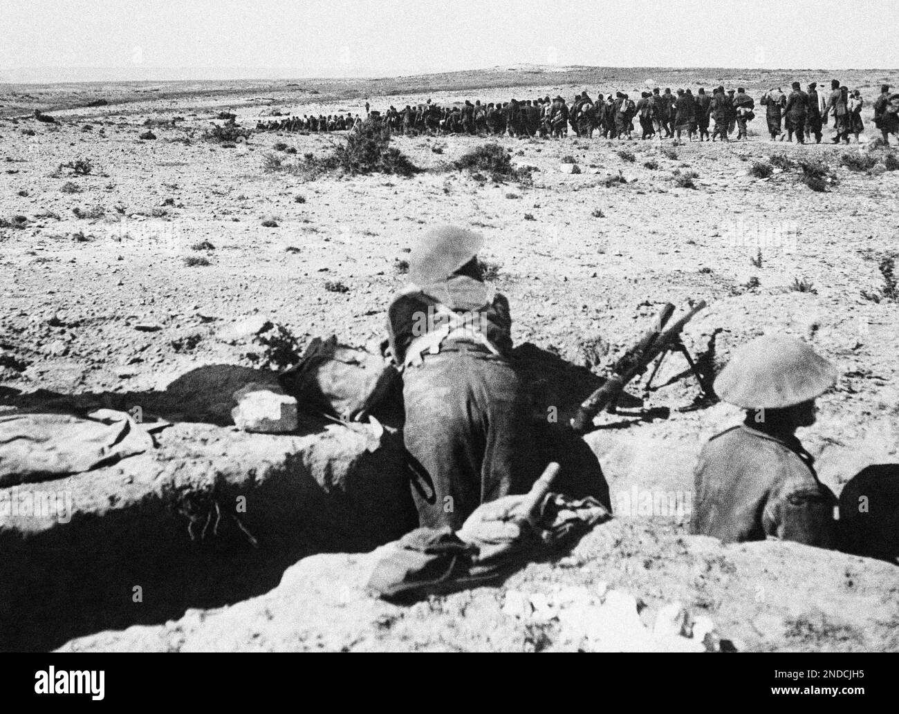 Soldiers of the victorious British Eighth Army look on from a trench in ...