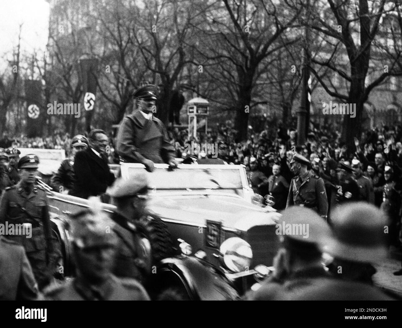 Standing upright in an open Grey-Green car, German Chancellor Adolf ...