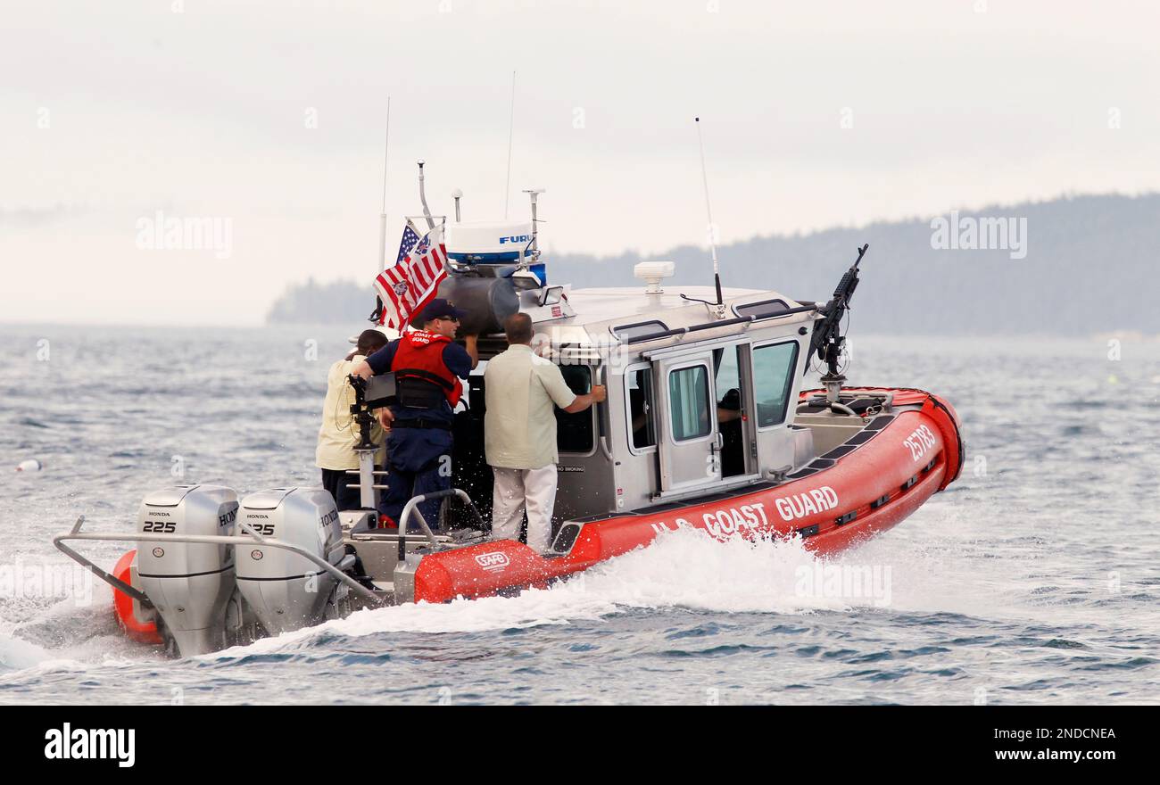 U.S. Secret Service agents accompany a Coast Guard boat as they follow ...