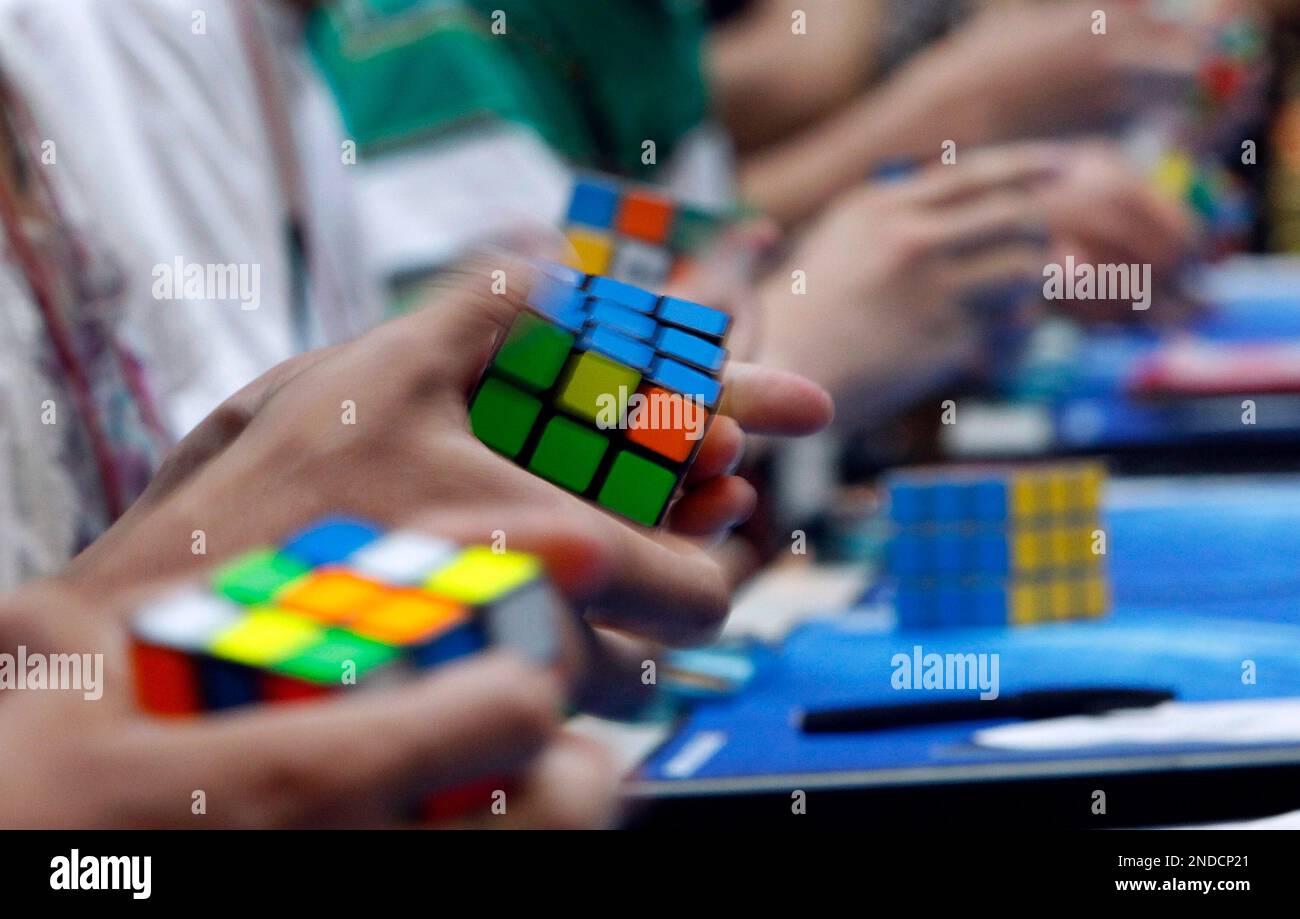 Participants solve Rubik's Cube for speed during 3X3X3 Rubik's Cube ...
