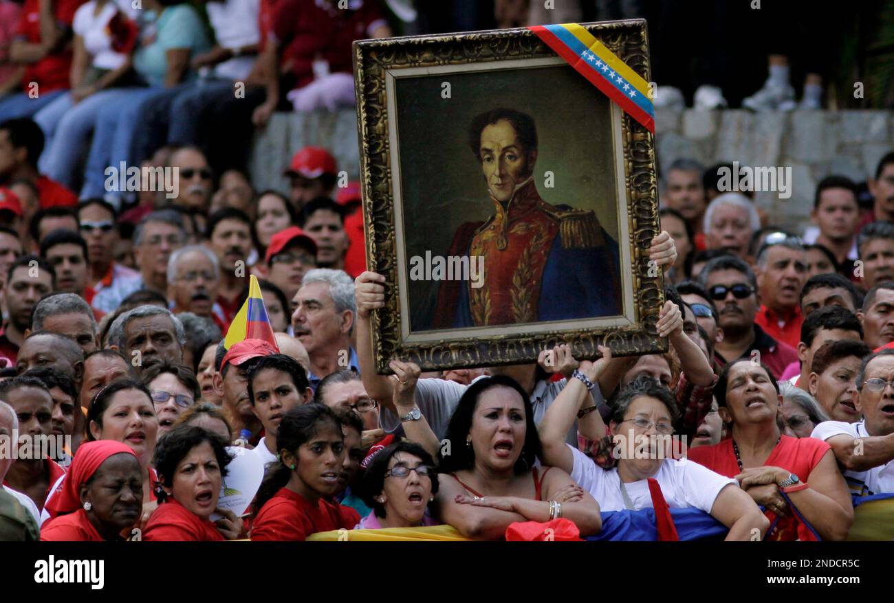 People hold a painting of Venezuela's independence hero Simon Bolivar ...
