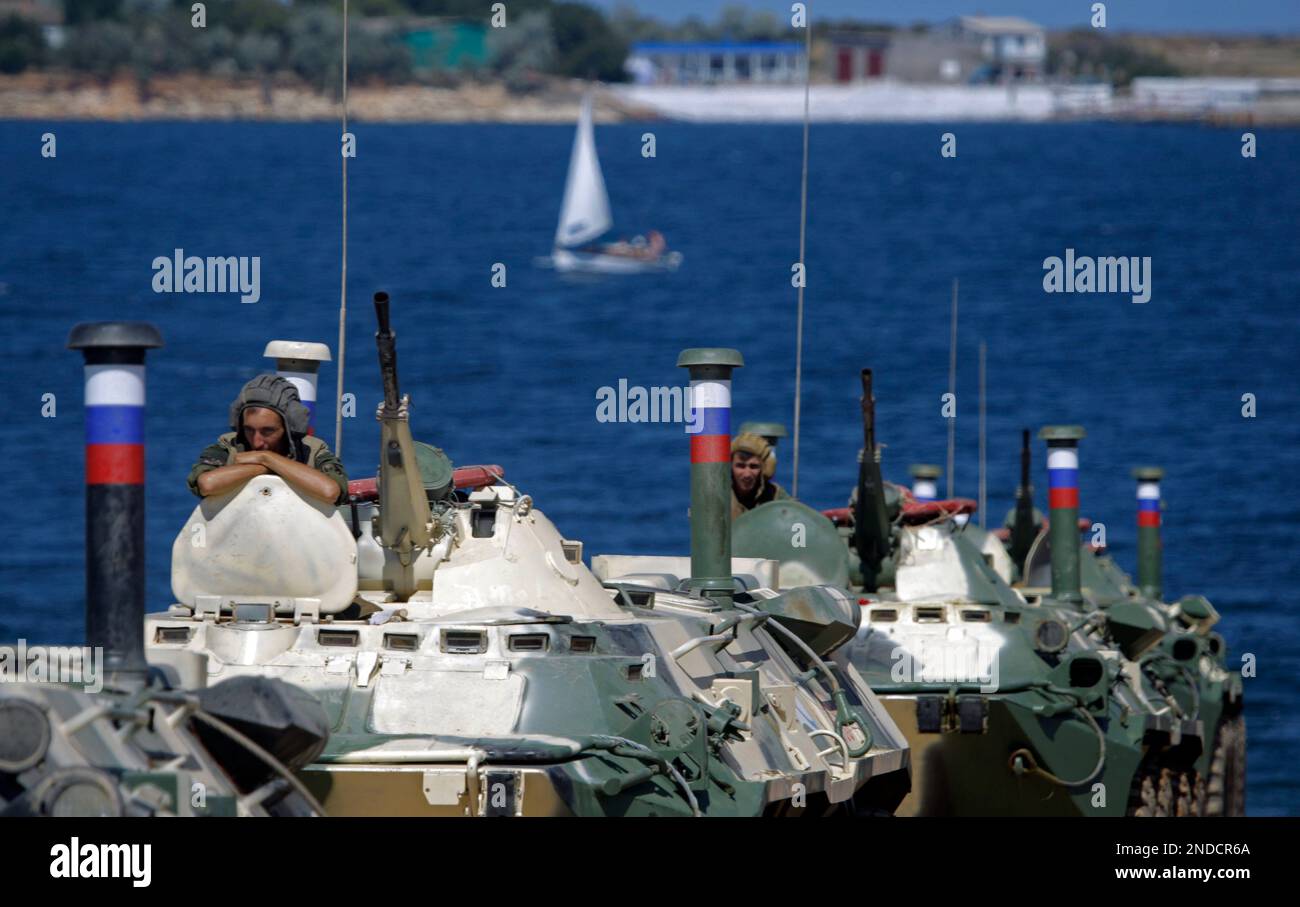 Russian Marines atop of the APC get ready to load onto the landing ship ...