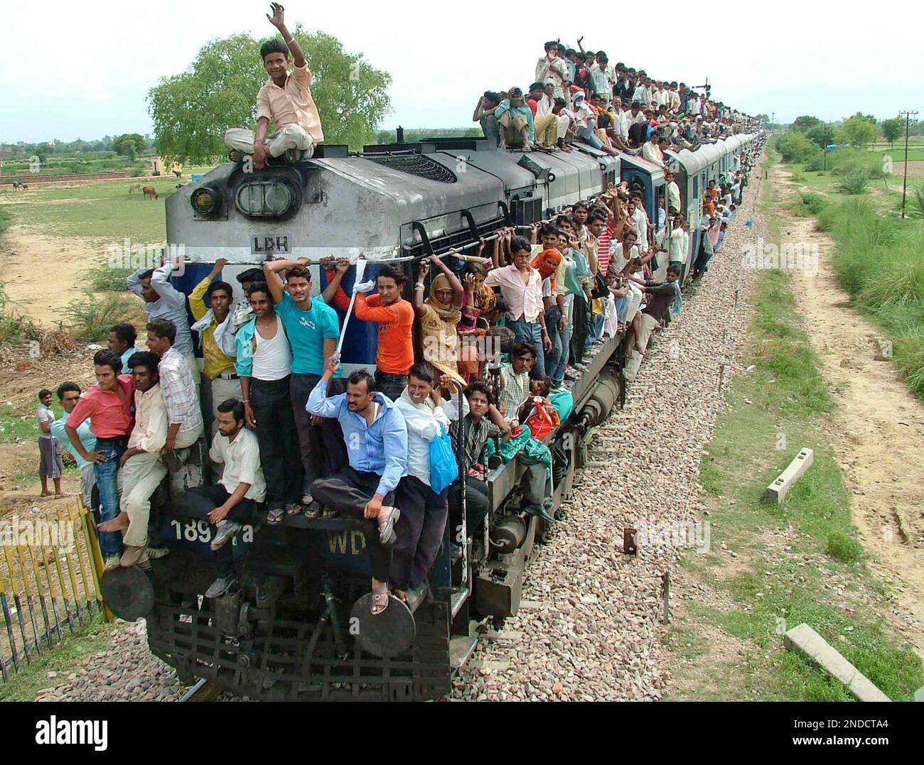 Hindu devotees travel on a crowded passenger train as they arrive for ...