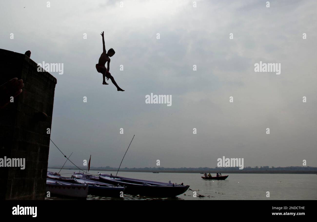 An Indian boy jumps into the River Ganges in Varanasi, India, Saturday ...
