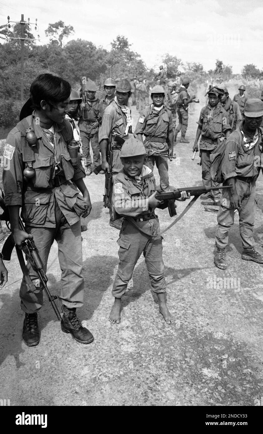 A young Cambodian soldier, still in his early teens, shows off with his ...