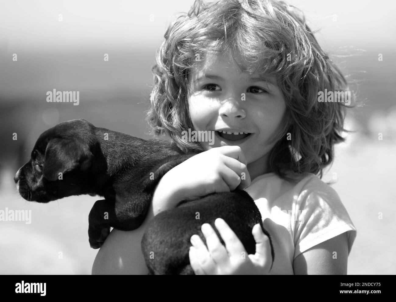 Happy child with puppy dog. Portrait kids boy with pet playing outside ...
