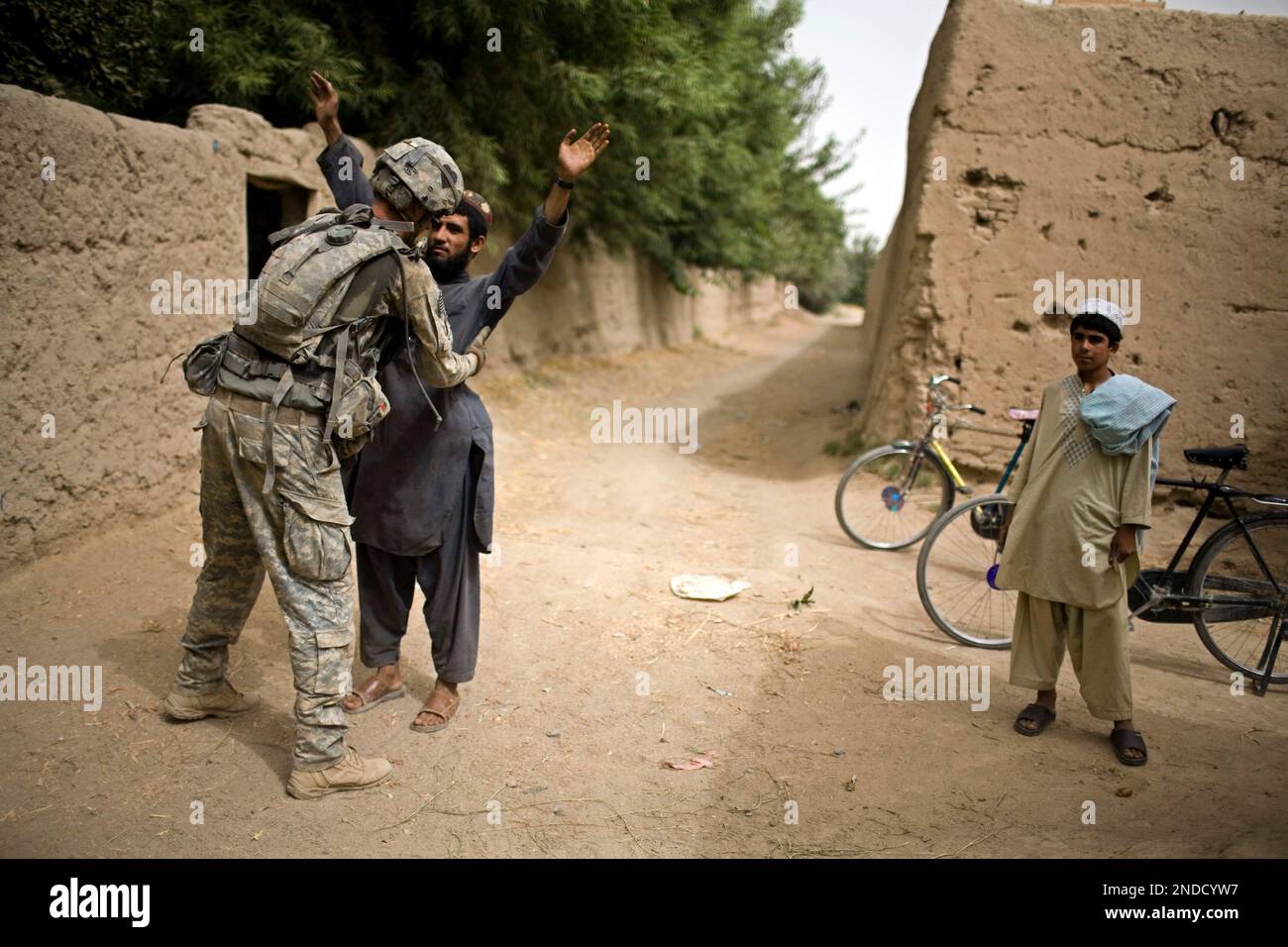 A U.S. Army soldier frisks an Afghan villager during a patrol by the 1 ...