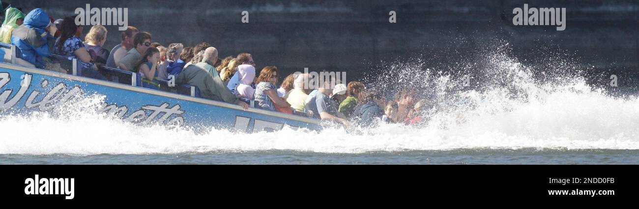 People are shown being splashed as a Willamette Jet Boat turns along ...
