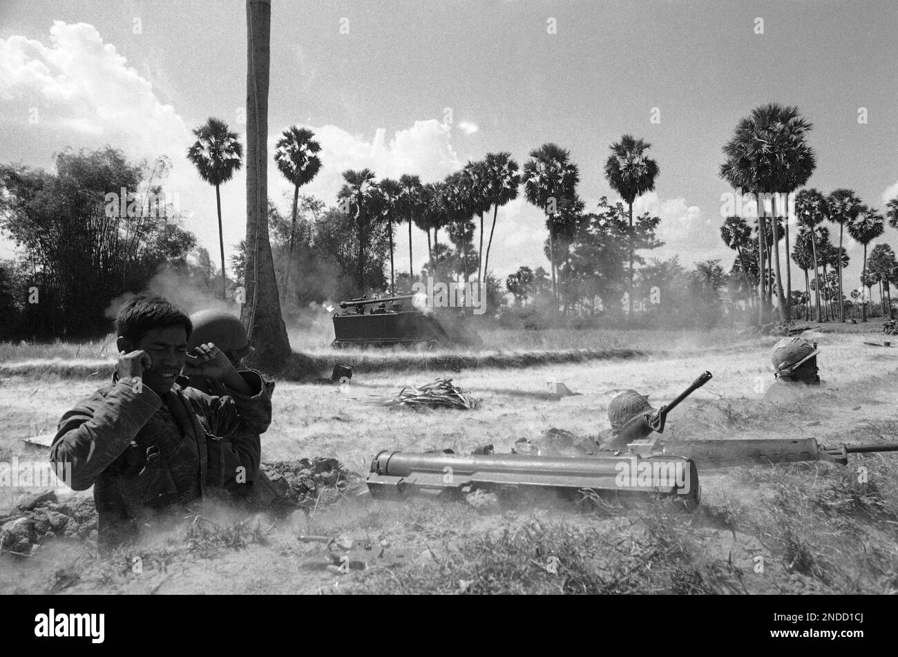 A Cambodian army soldier covers his ears as he crouches with companions ...