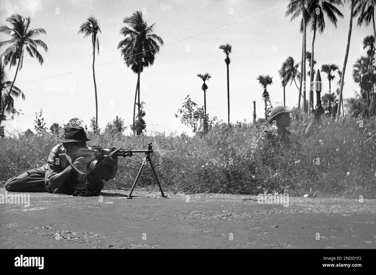 Cambodian soldier fires Chinese-made machine gun down a road near the ...