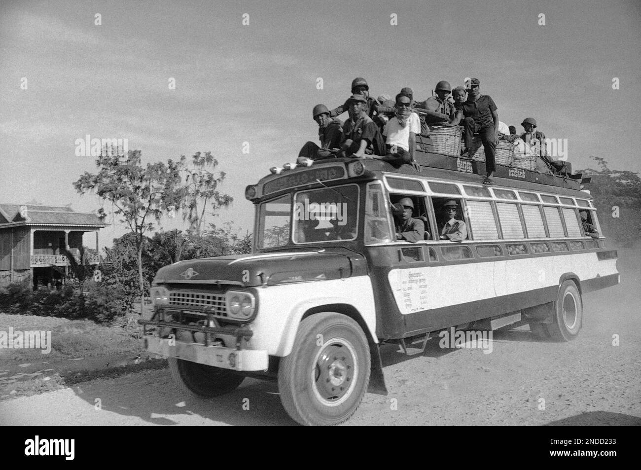 Cambodian soldiers crowd into and atop a bus moving along Cambodia’s ...