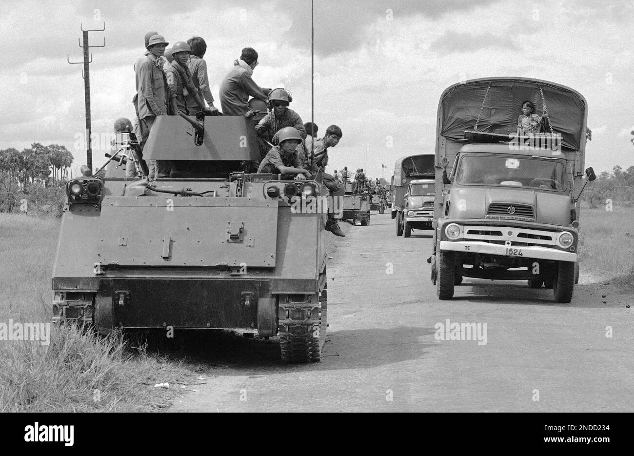 Cambodian soldiers watch from atop armored personnel carriers, the ...