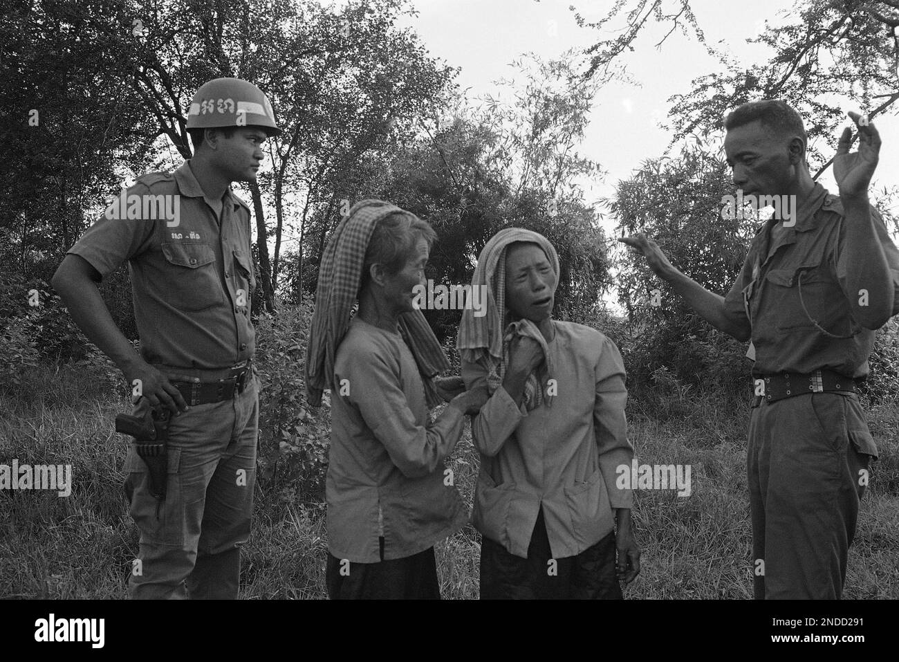 A Cambodian officer questions two elderly women who survived U.S. bombing raid August 6 on Neak ...