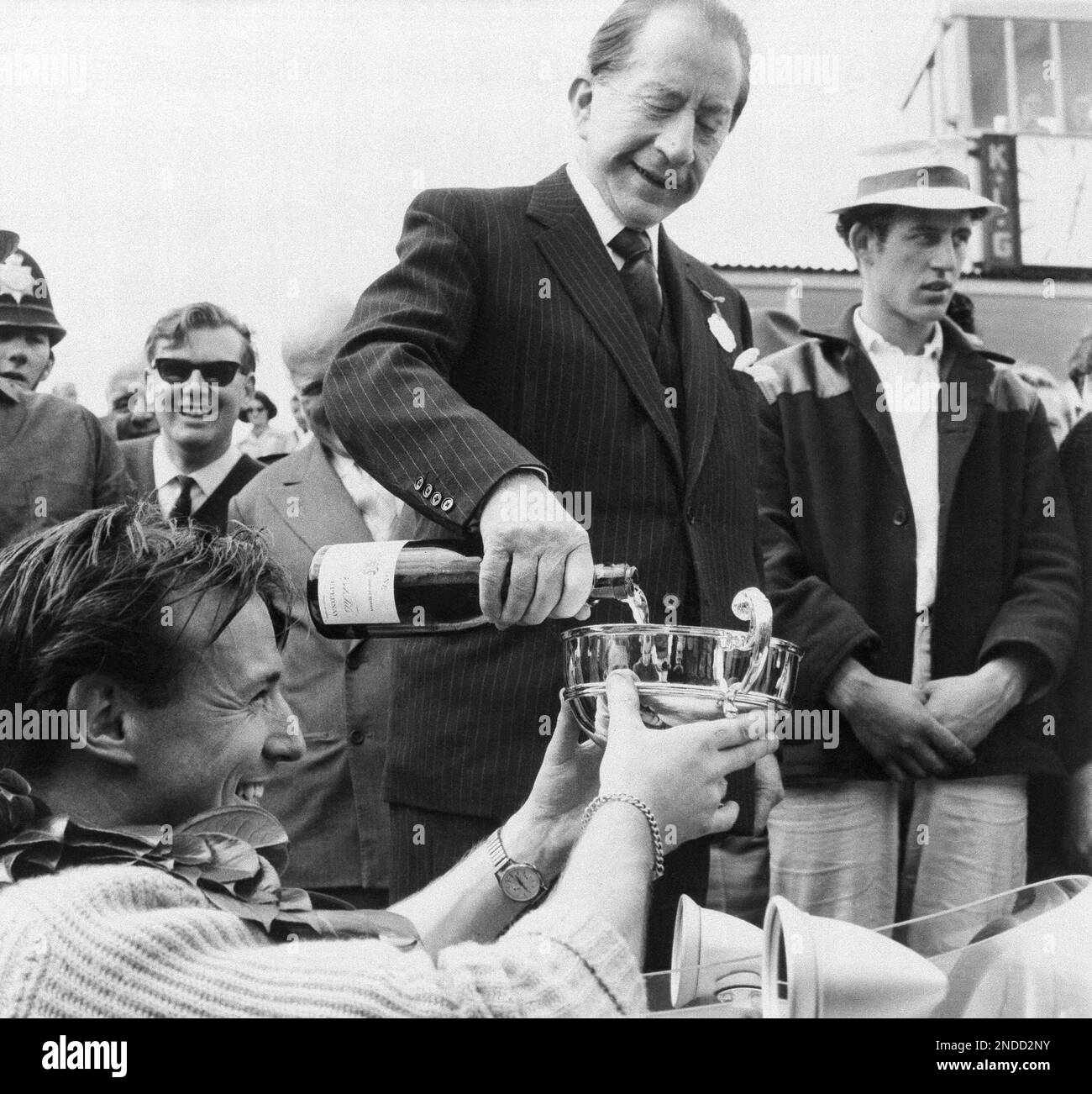 British racing driver Bob Burnard holds up the Veedol Trophy as ...