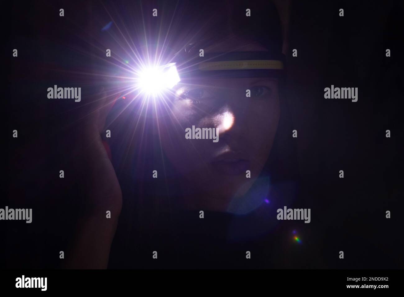 A girl with a headlamp shines in the dark, the light of a lantern Stock ...