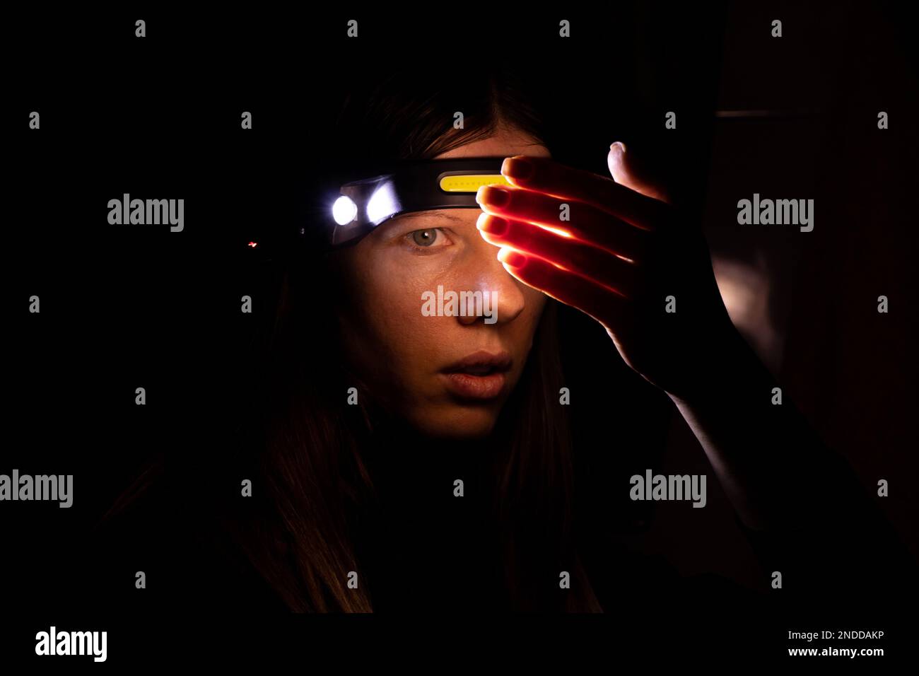 A girl with a headlamp shines in the dark, the light of a lantern Stock ...