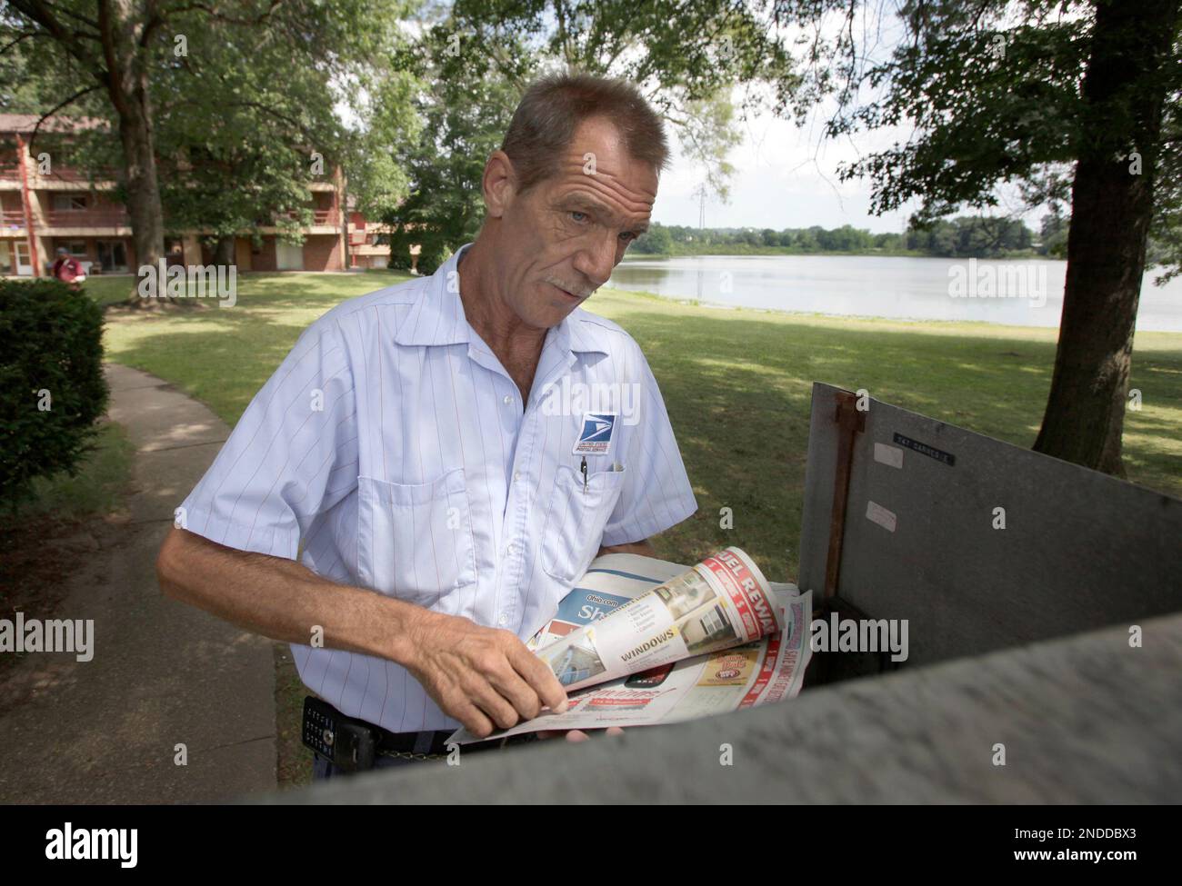 Ohio letter carrier Keith McVey sorts mail into post boxes at an ...