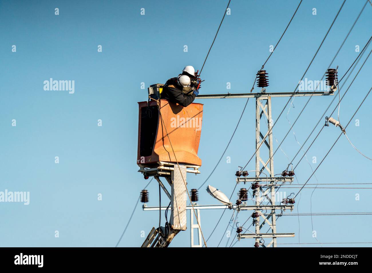 Electrical workers are making a high voltage connection. Electricity ...