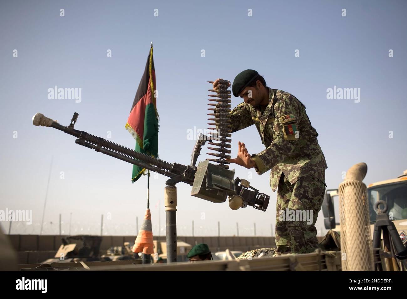 An Afghan National Army soldier prepares a machine gun before going on ...