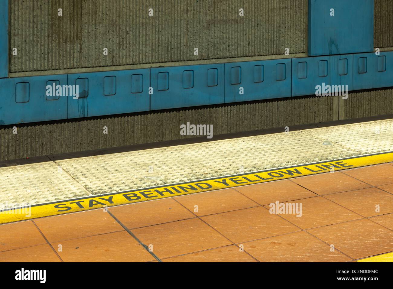 A picture of tje "Stay Behind Yellow Line" sign at a sunway station ...