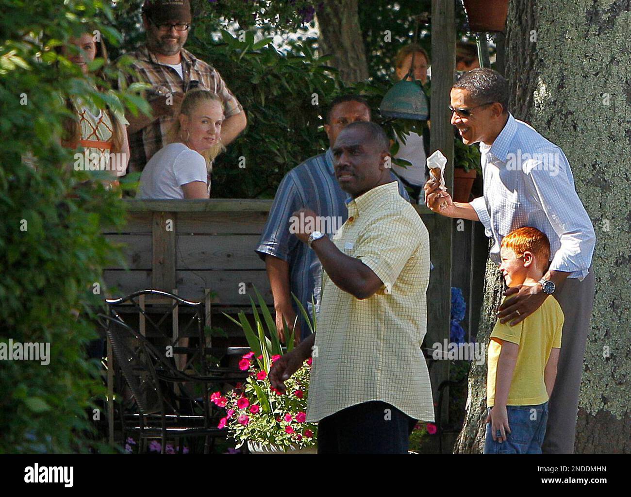 President Barack Obama holds an ice cream cone while posing with a boy ...