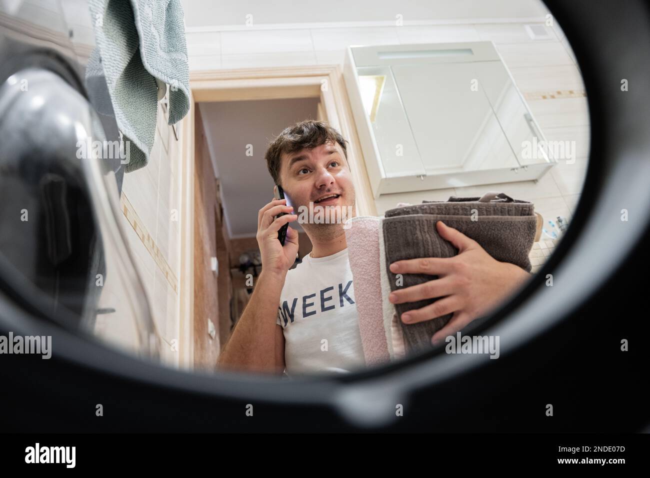 Man view from washing machine inside, speaking by phone with wife. Male ...
