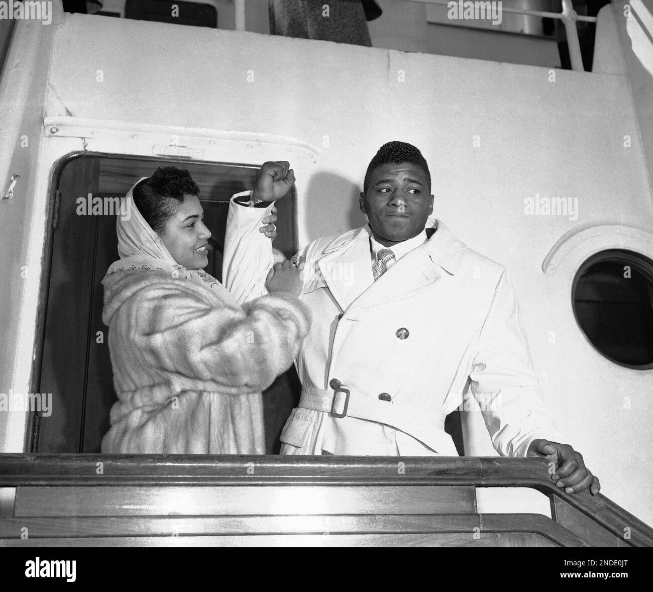 Mrs. Floyd Patterson feels the muscle of her husband aboard the liner ...