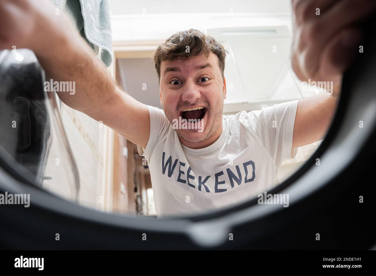 Man view from washing machine inside. Male does laundry daily routine ...