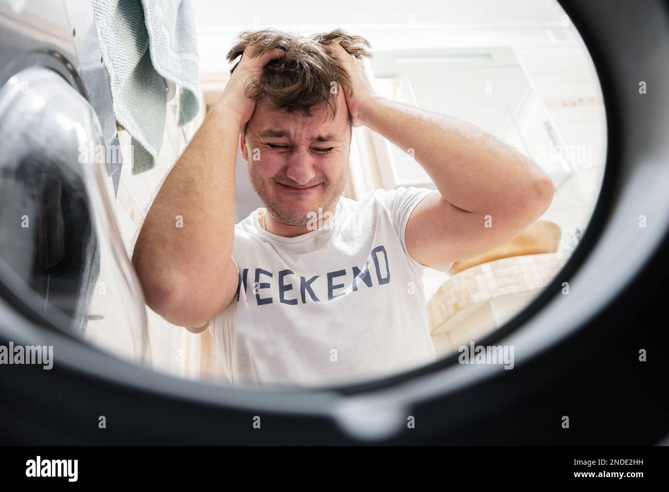 Man view from washing machine inside. Male does laundry daily routine ...