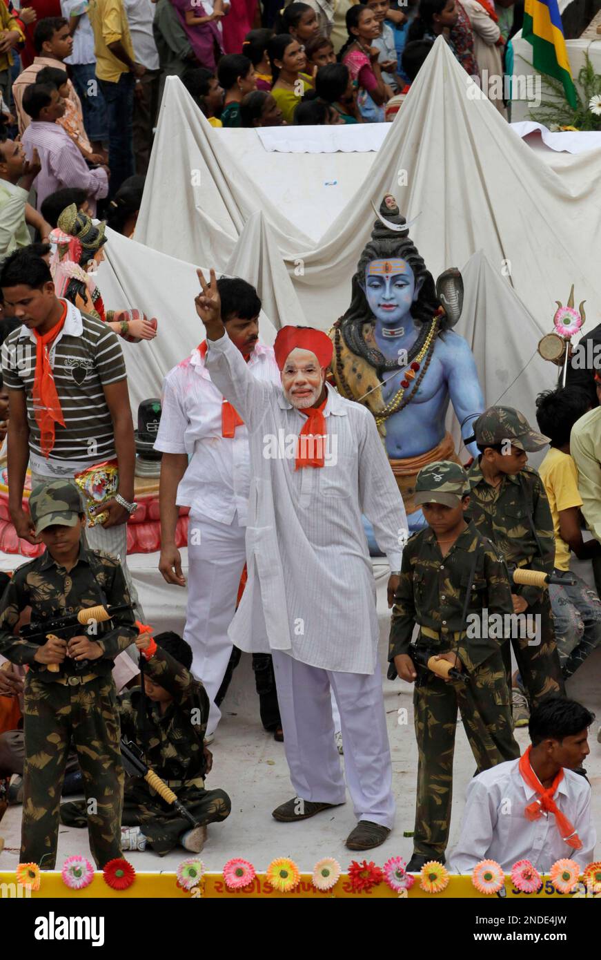 A man wearing Gujarat state chief minister Narendra Modi's mask, center ...