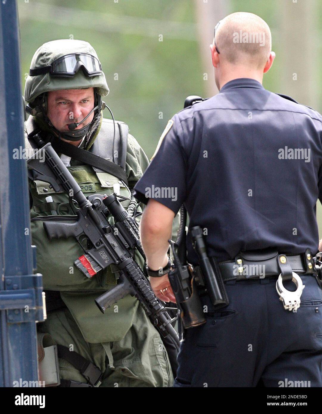 Police return to a base station after searching for suspects in a home ...