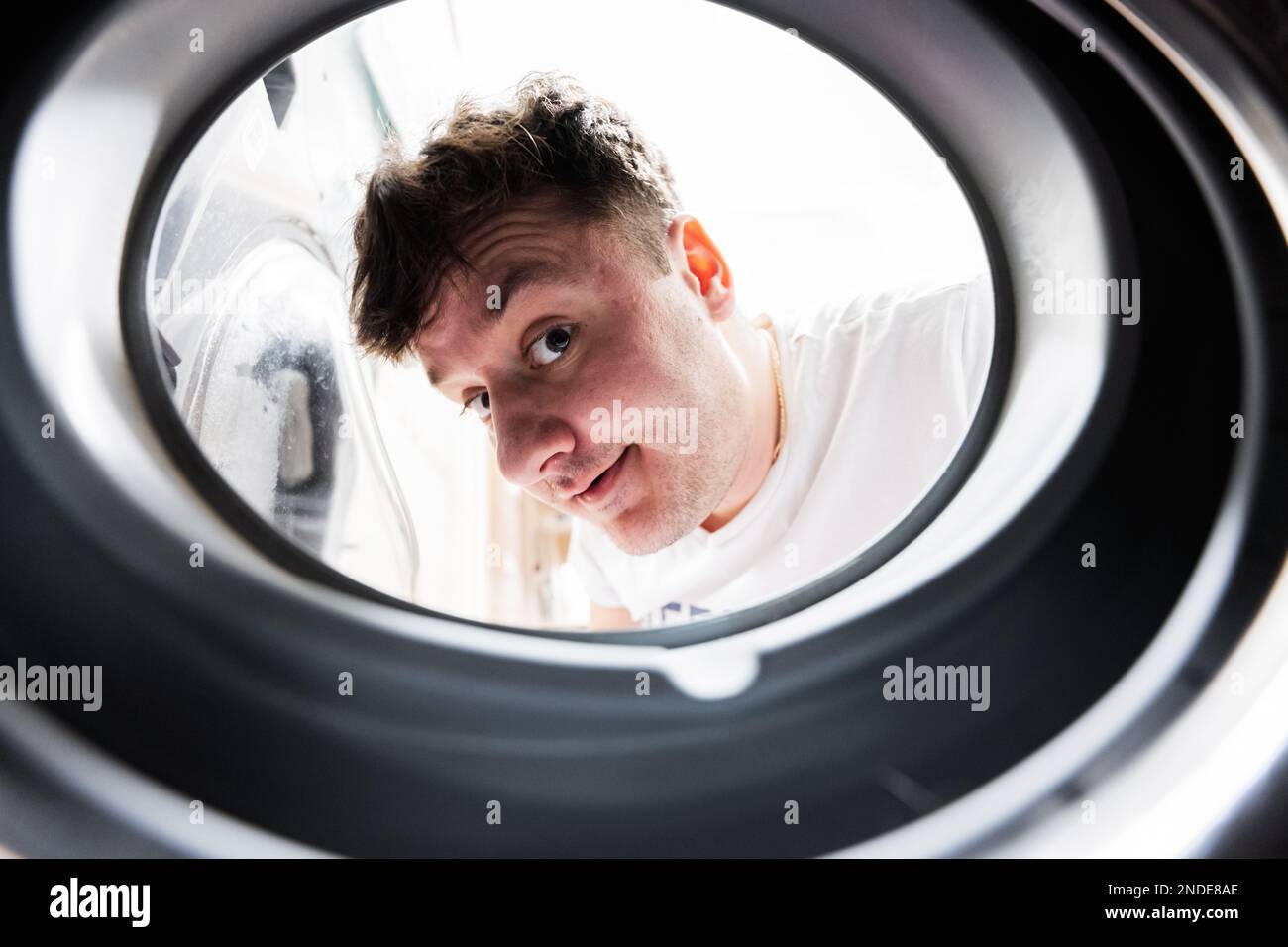 Man view from washing machine inside. Male does laundry daily routine ...