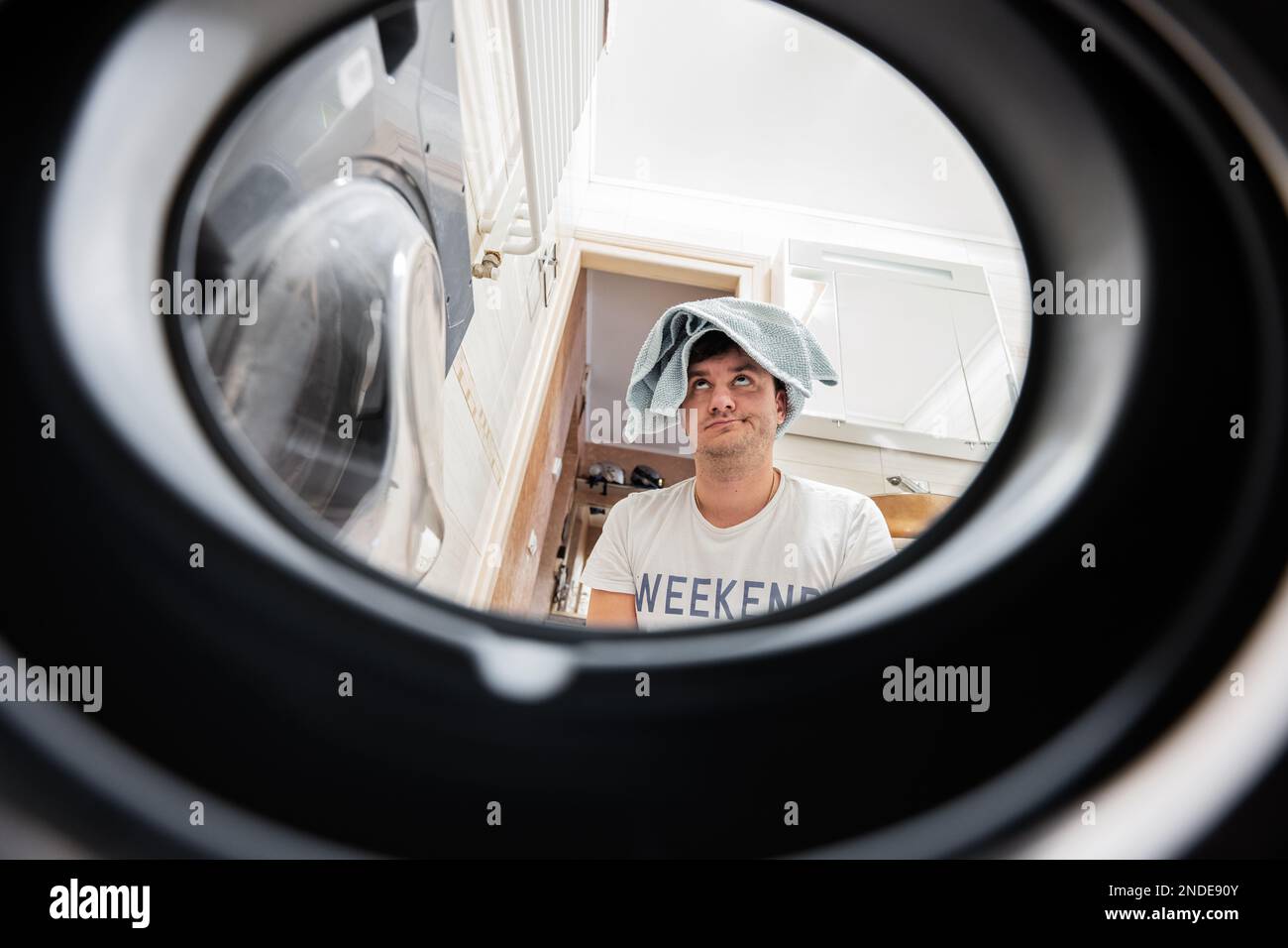 Man view from washing machine inside. Male does laundry daily routine ...