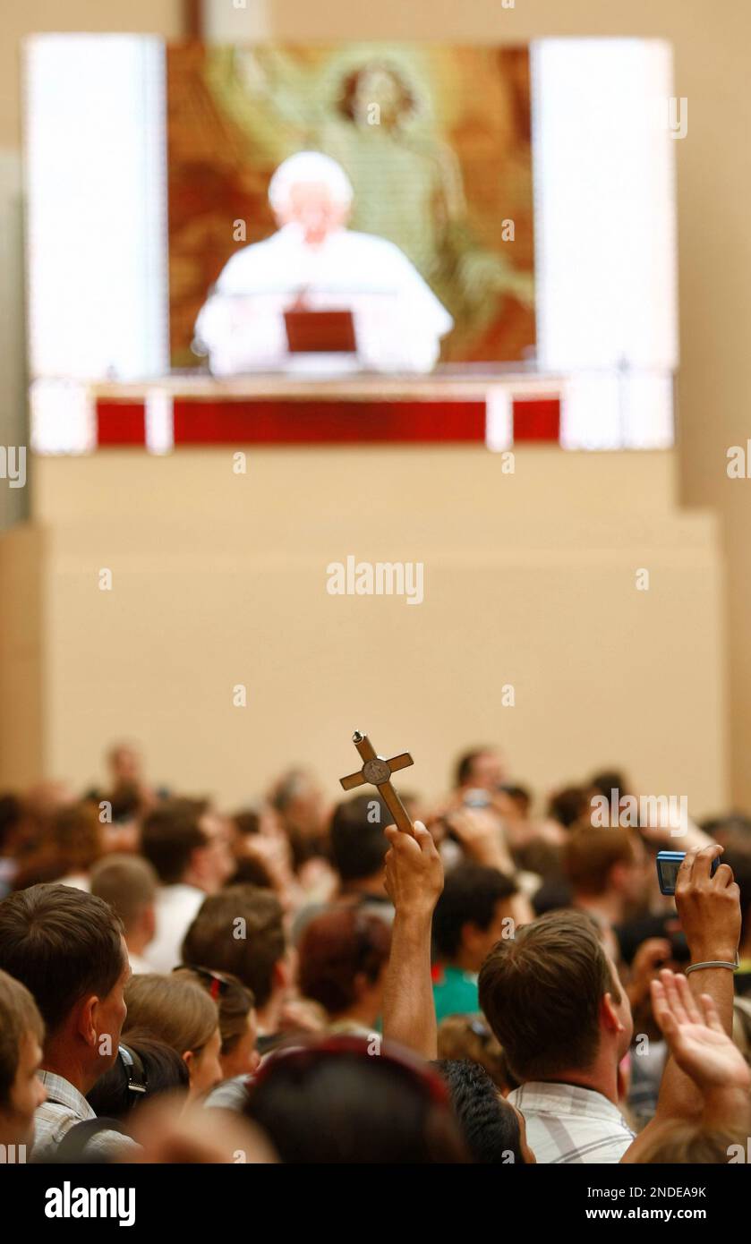 A faithful holds a cross during Pope Benedict XVI's Angelus prayer at ...