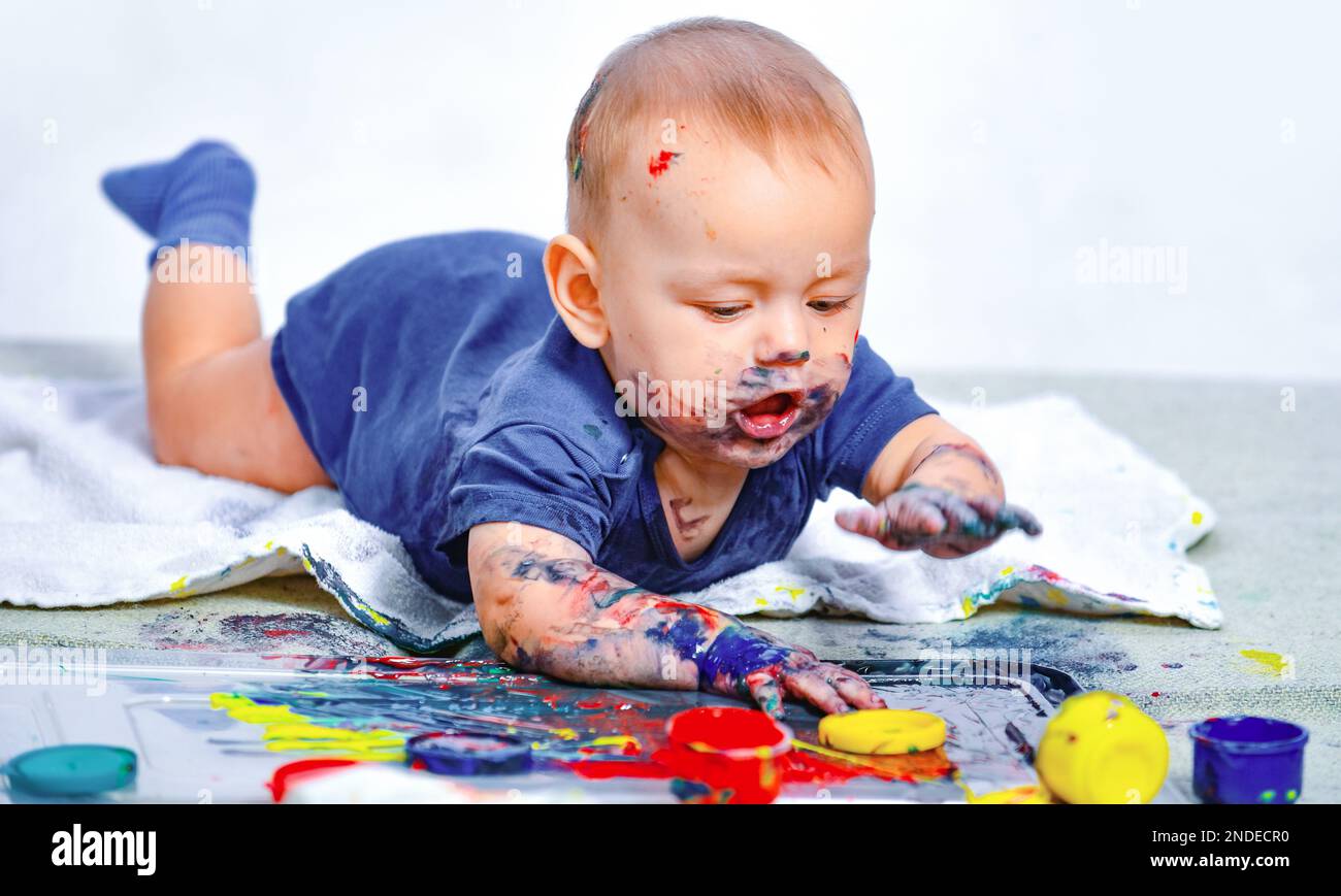 Colorful painted hands in a baby. Beautiful happy baby. Cute little ...