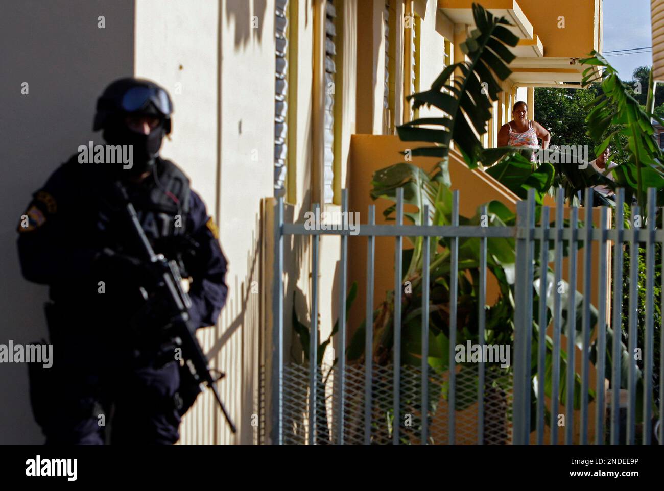A resident of a public housing project, behind right, watches police ...