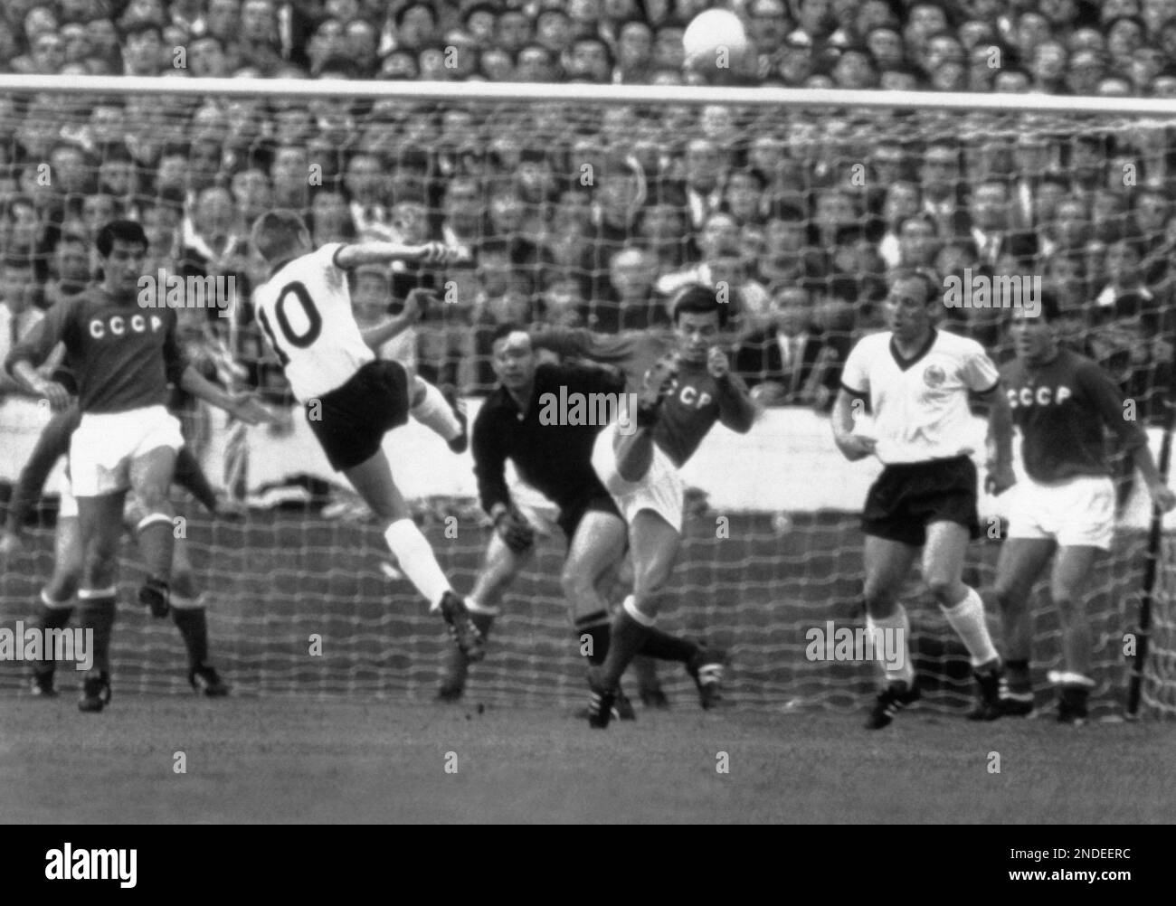 West German forward Sigfried (Siggi) Held (No. 10) shot at goal is ...