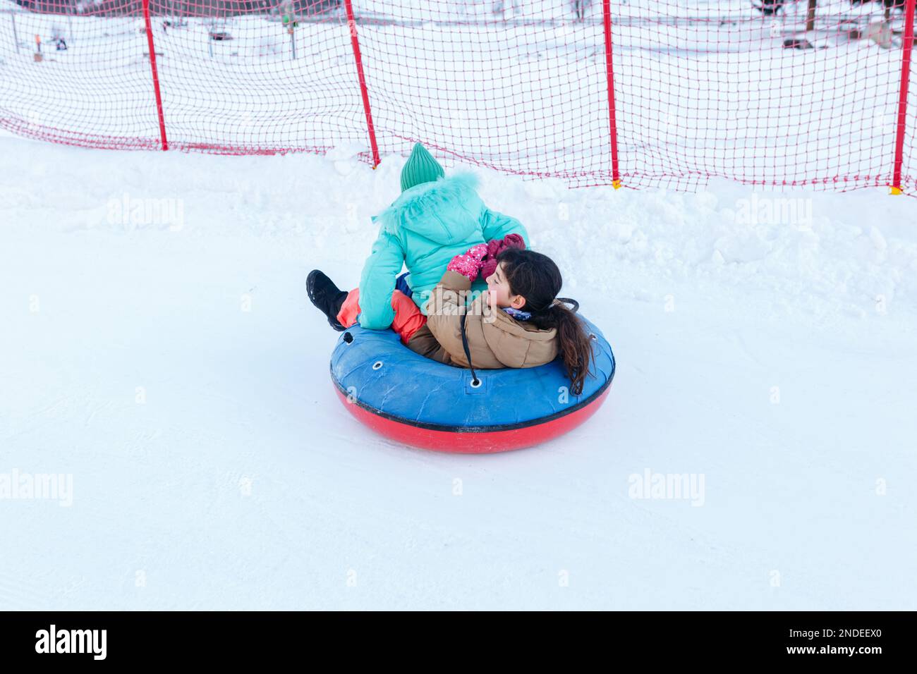 two children sledding on snow slope in one snow bob Stock Photo - Alamy