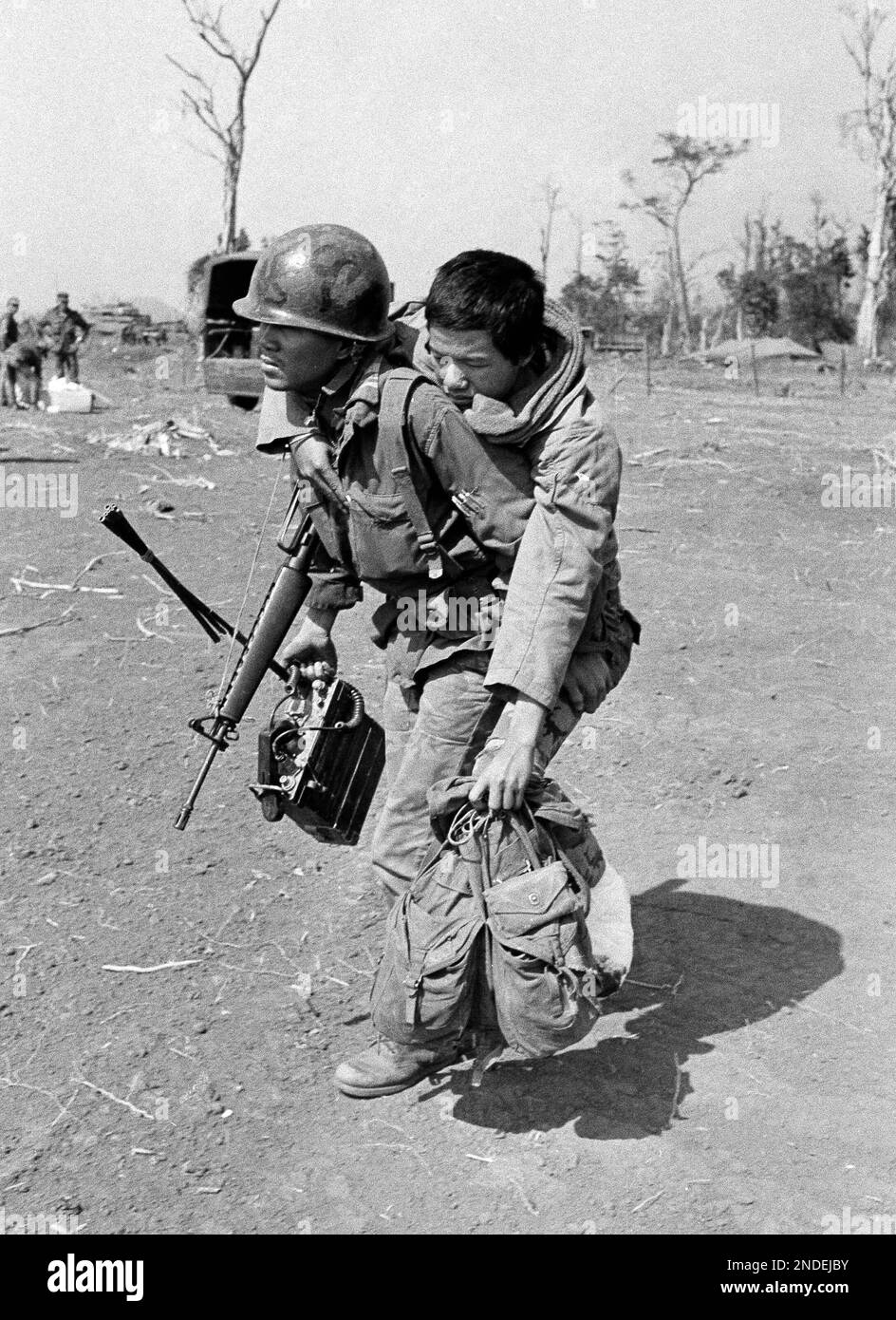 A South Vietnamese trooper carries a wounded buddy on his back at the ...