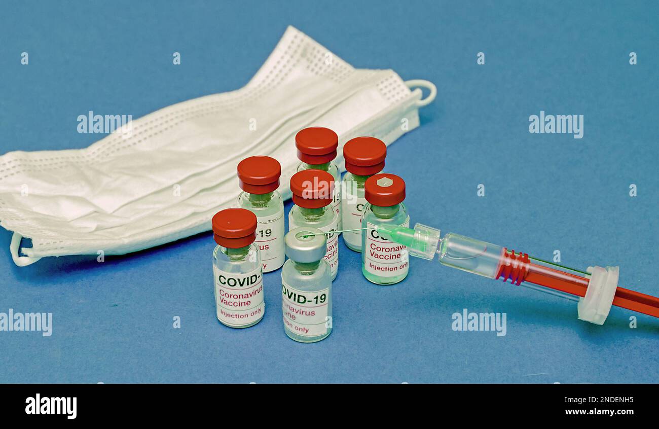Covid-19 vaccine glass vials and full plastic syringe with sharp needle ...