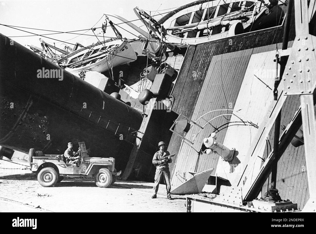 A U.S. army soldier with a sub-machine gun and another in a peep guard ...
