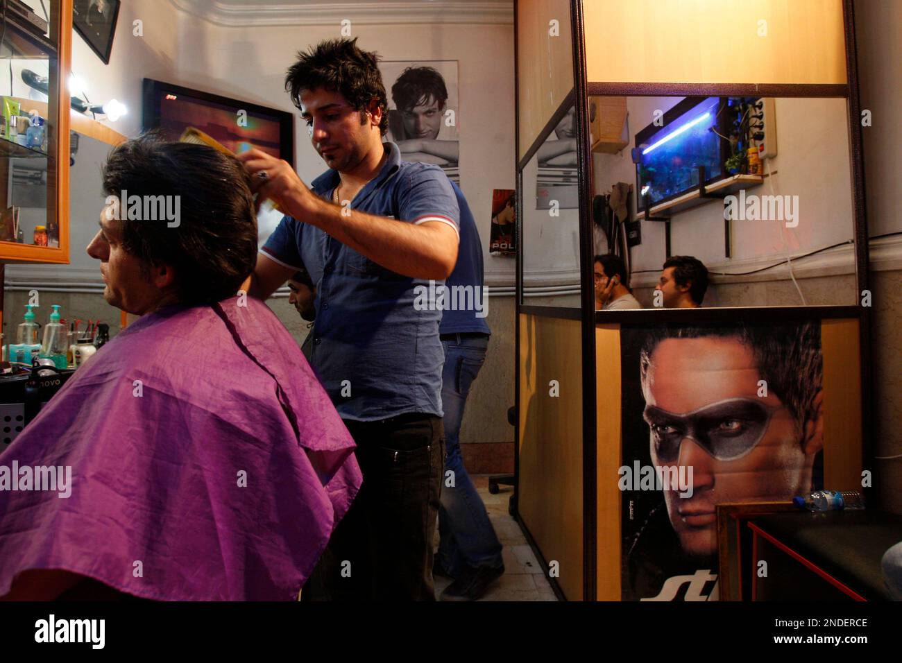 An Iranian barber cuts hair in his barber shop in midtown Tehran, Iran ...